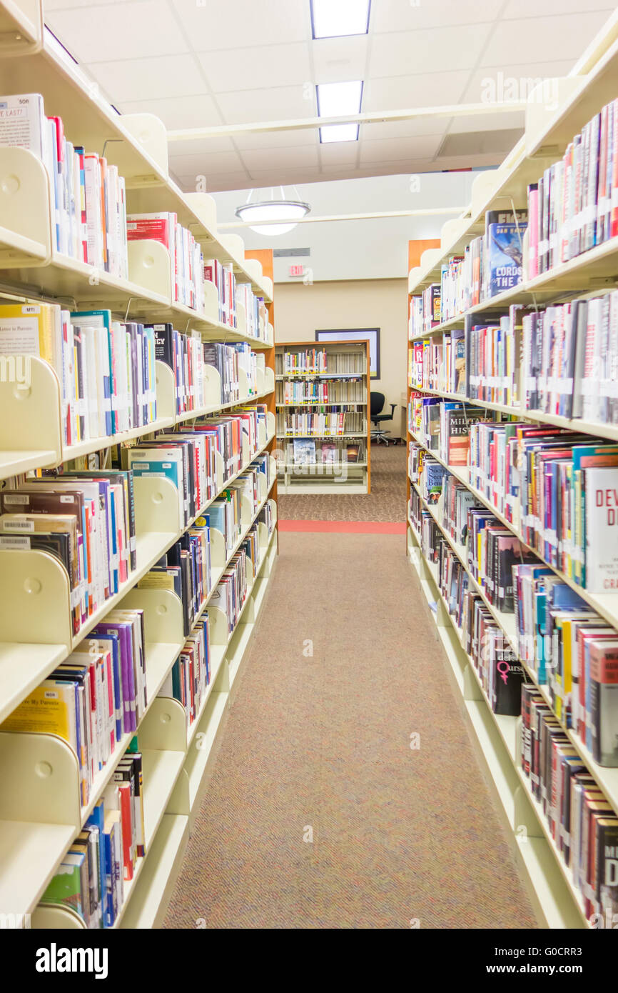 A view of rows of bookshelves and a study area inside a modern library ...
