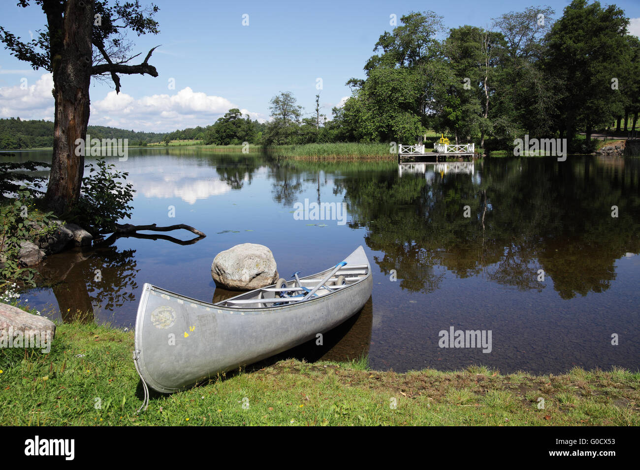 Canoe on still lake Stock Photo - Alamy