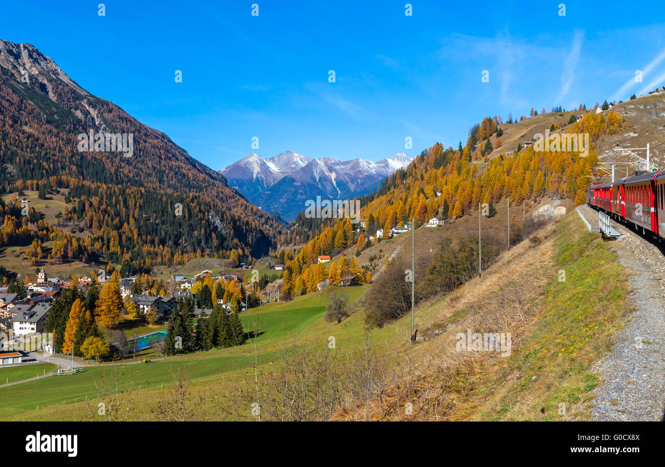 Travel with train of Rhaetian Railway in golden autumn through the line ...