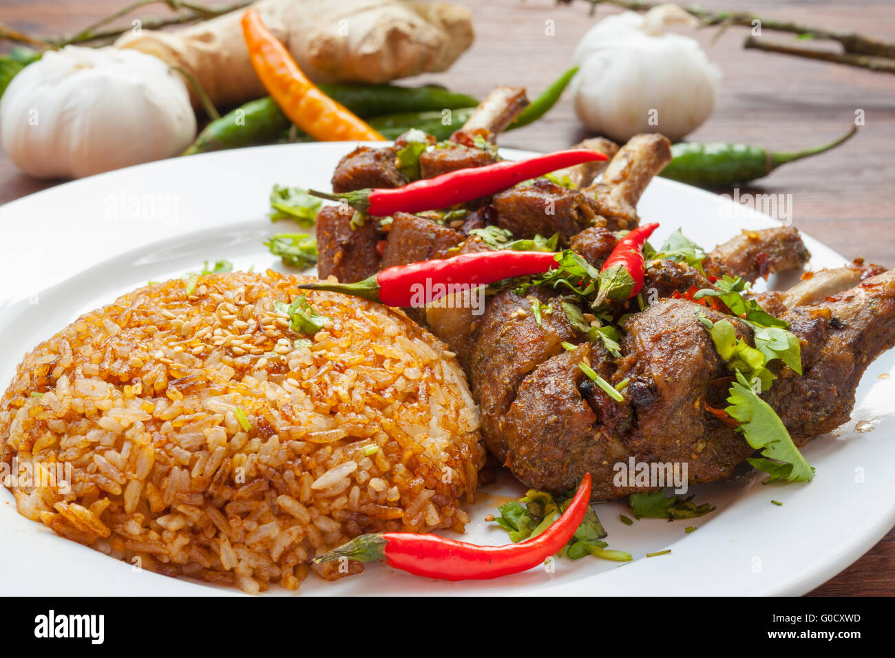 Close up view of grilled lamb chop served with rice, with spicy red ...