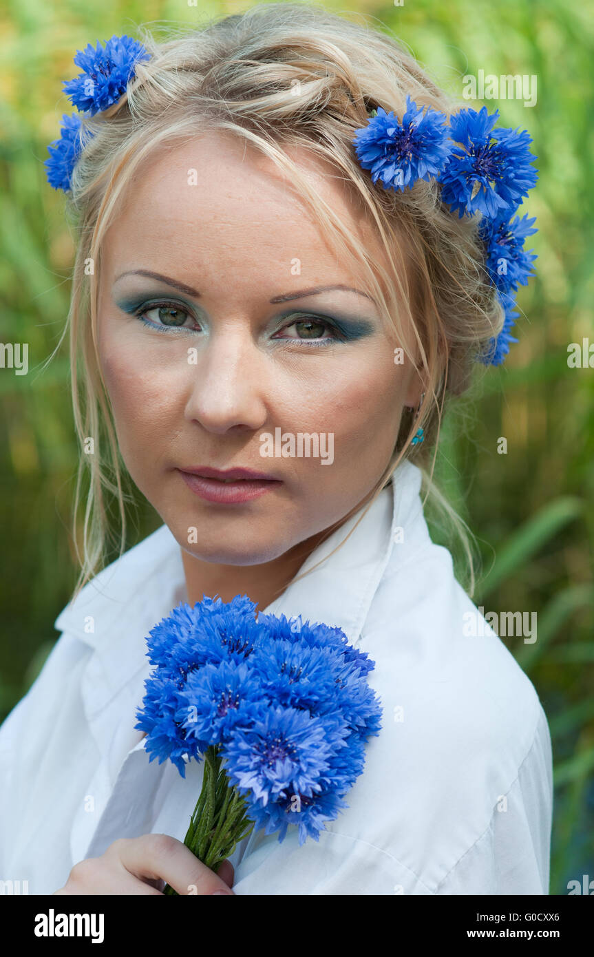 Portrait of beautiful female with blue flowers Stock Photo - Alamy