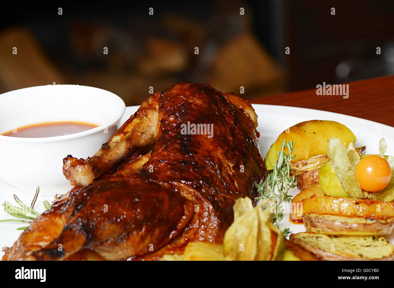 The baked half of duck with a potato, apples and pineapple Stock Photo ...