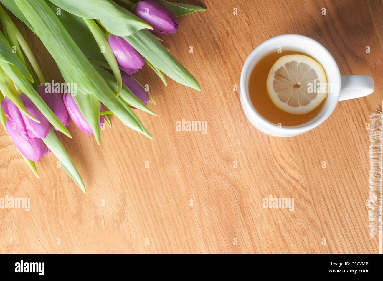 Violet tulips on the wood and tea, top view Stock Photo - Alamy