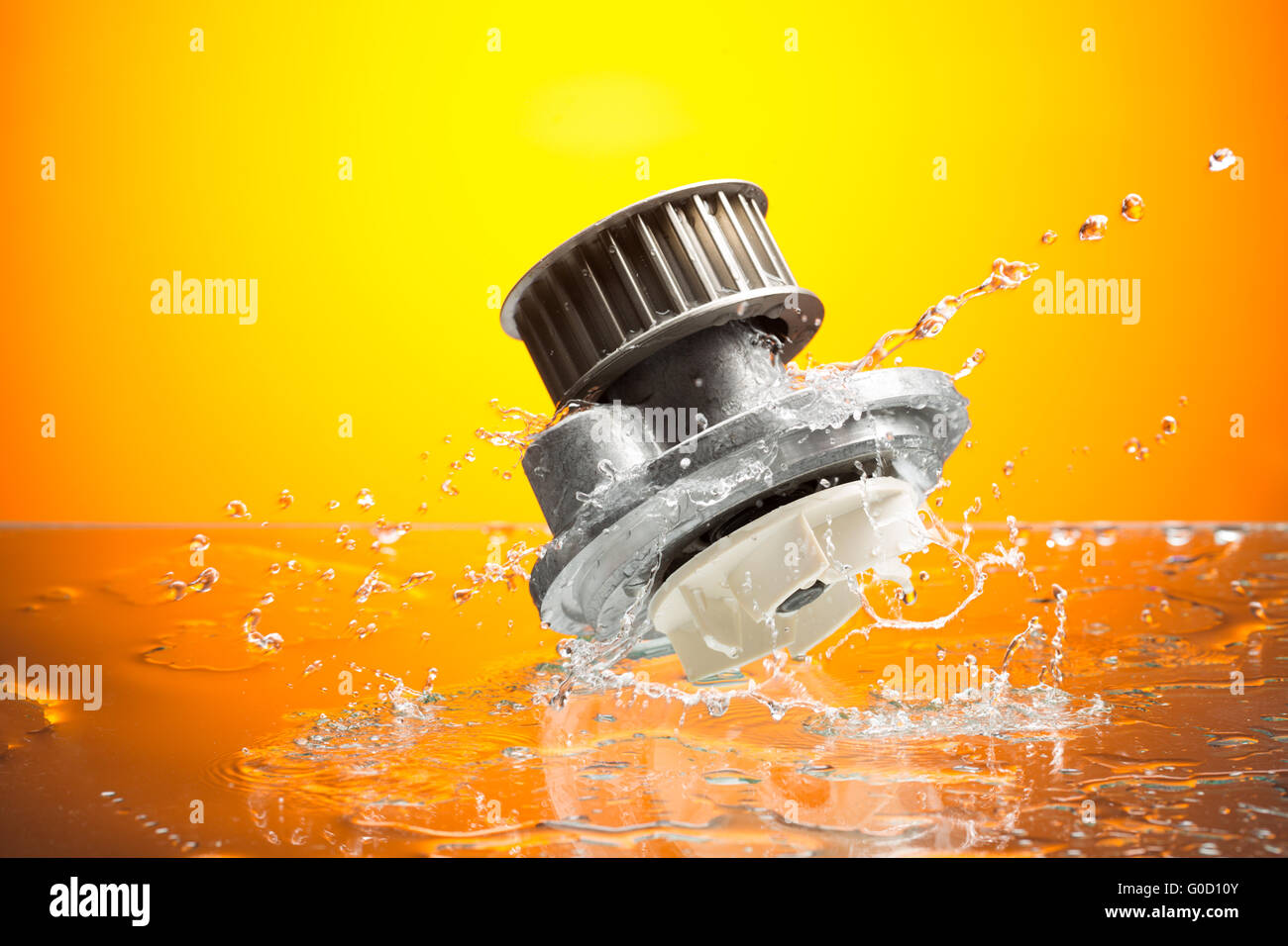 Auto parts, engine cooling pump in water splash on orange background ...