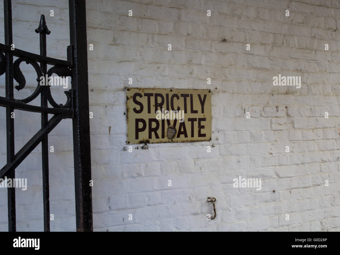 Strictly Private sign on white brick wall on a gated alleyway leading ...