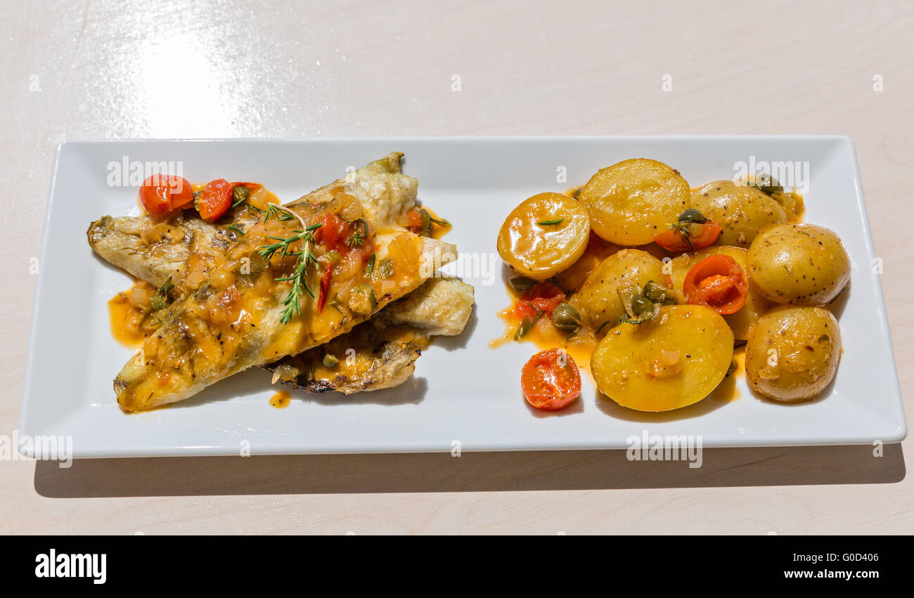 Plate of cooked fish and potatoes in sauce Stock Photo - Alamy