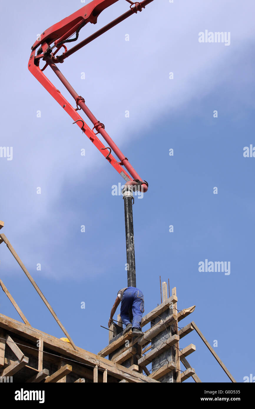 Builder worker with tube from truck mounted concrete pump Stock Photo ...