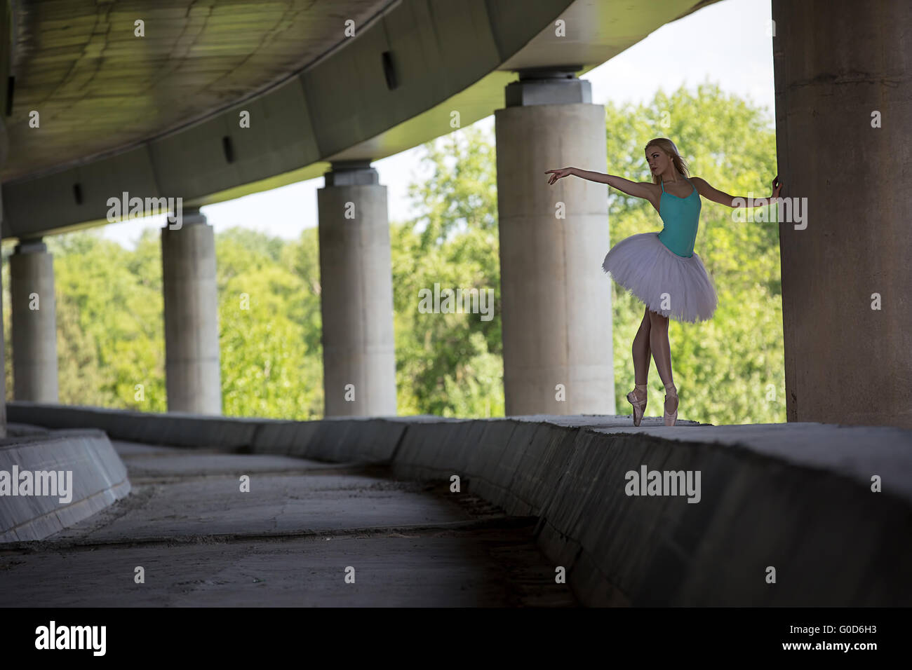 Graceful ballerina doing dance exercises on a concrete bridge Stock ...