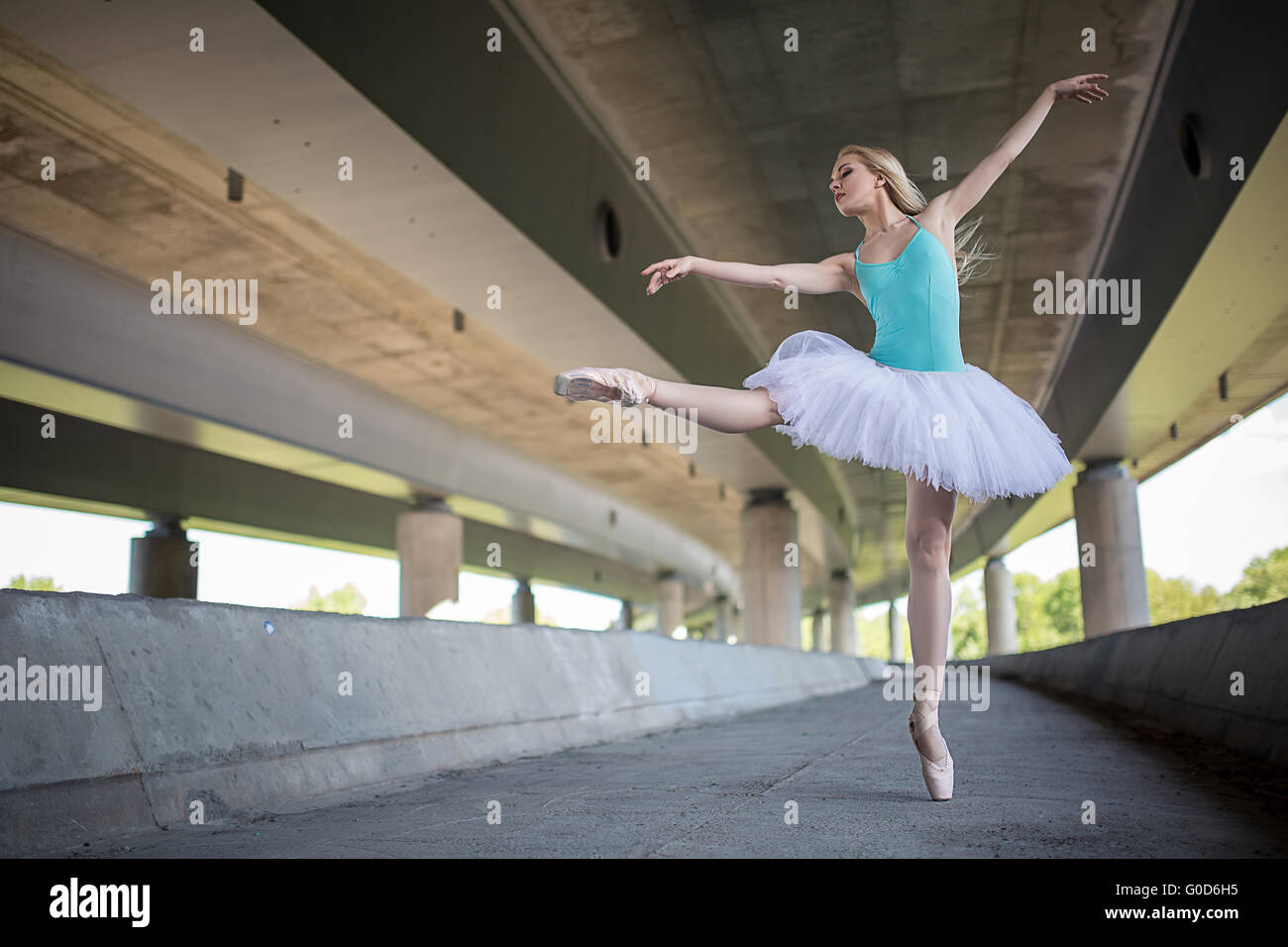 Graceful ballerina doing dance exercises on a concrete bridge Stock ...