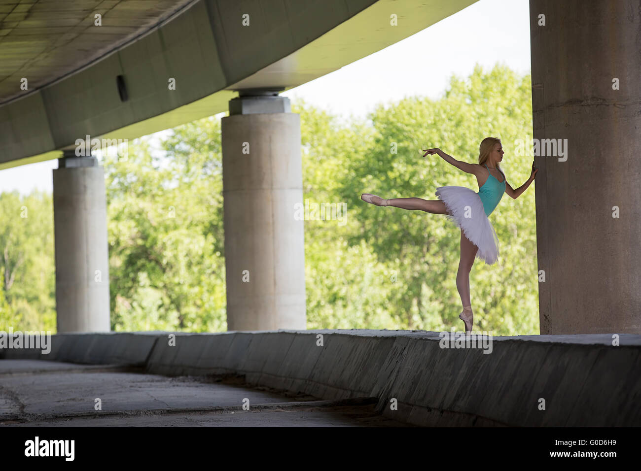 Graceful ballerina doing dance exercises on a concrete bridge Stock ...