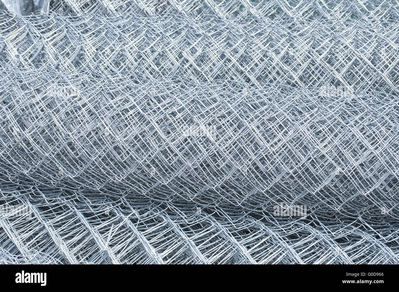 Rolled up metal galvanized fence nets closeup Stock Photo - Alamy