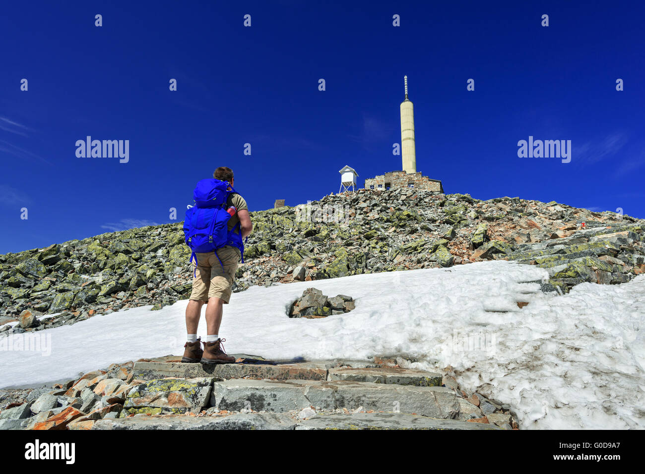 Hiker with big traveling rucksack looking forward on the mountain trail ...
