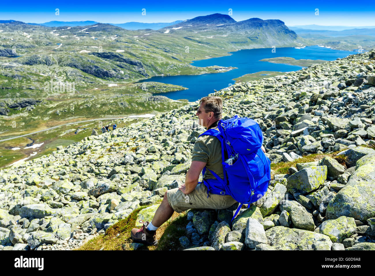 Hiker with big traveling rucksack looking forward on the mountain trail ...