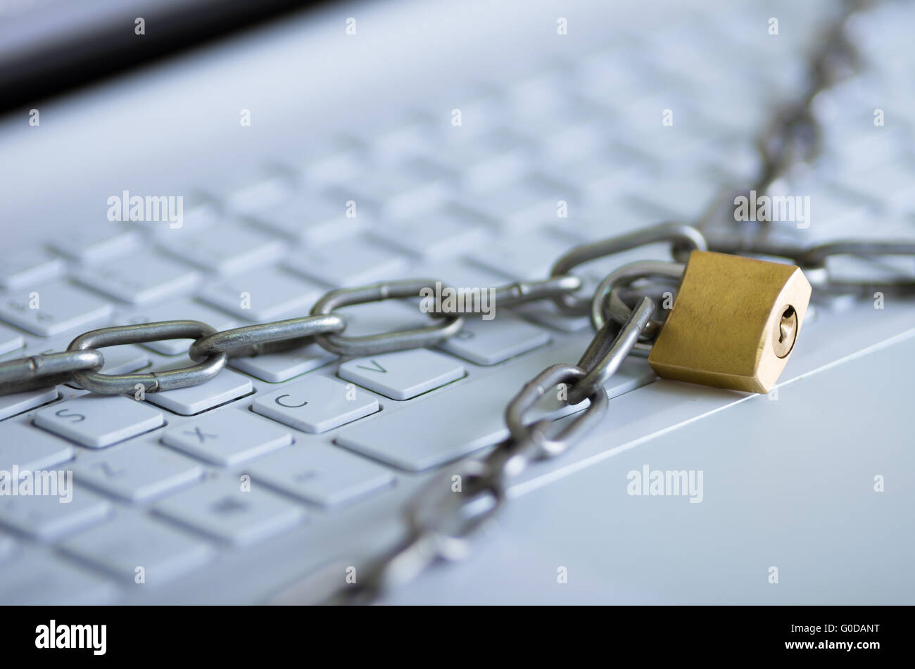Padlock With Metal Chain Hooked And Locked Across Computer Keyboard
