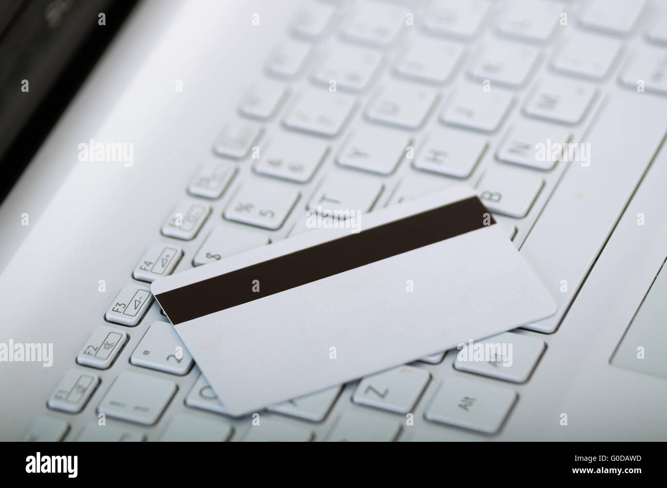 Closeup white electronic swipe card with magnetic stripe visible lying ...