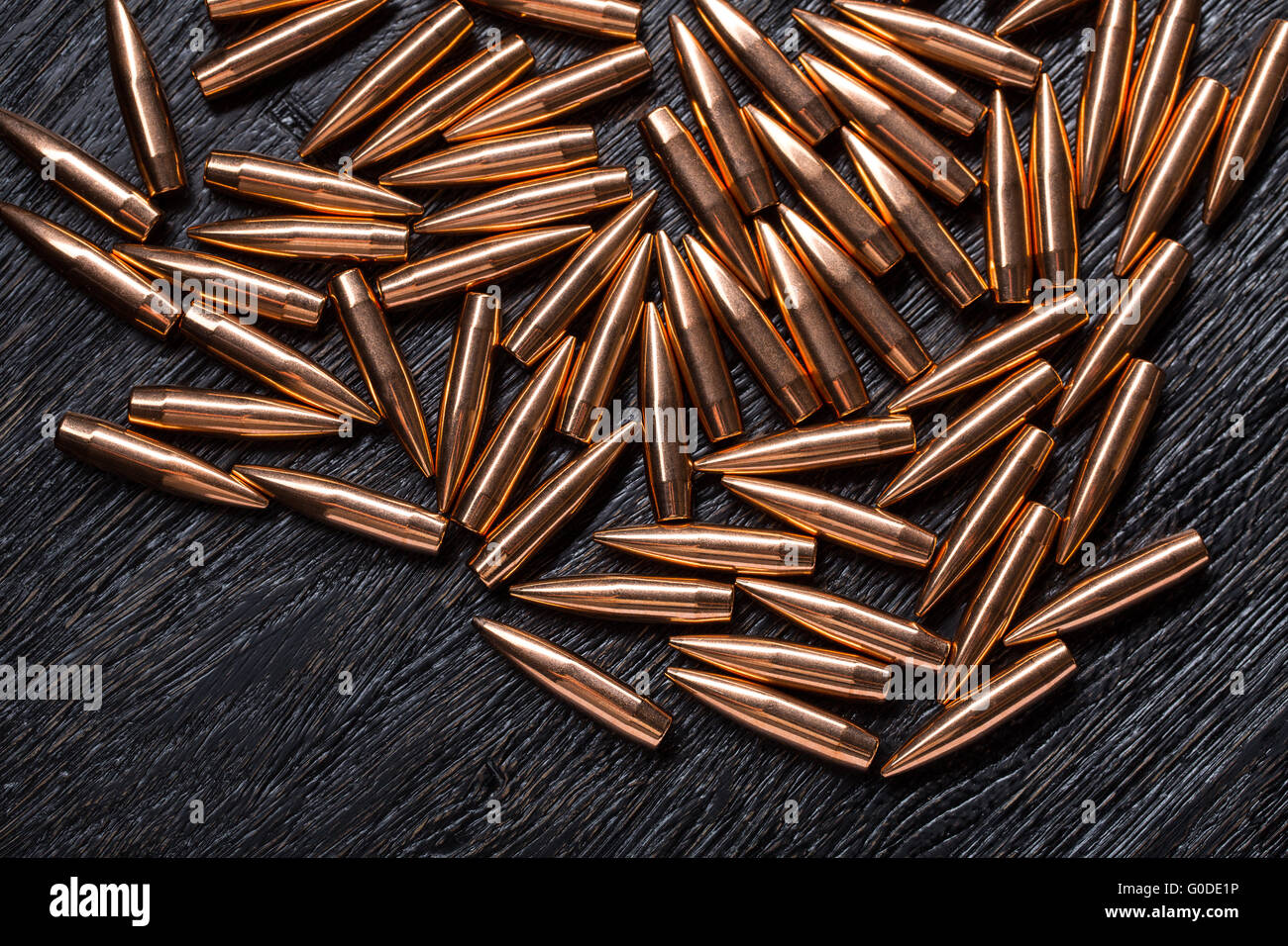 Placer copper bullets on a dark wooden background Stock Photo - Alamy
