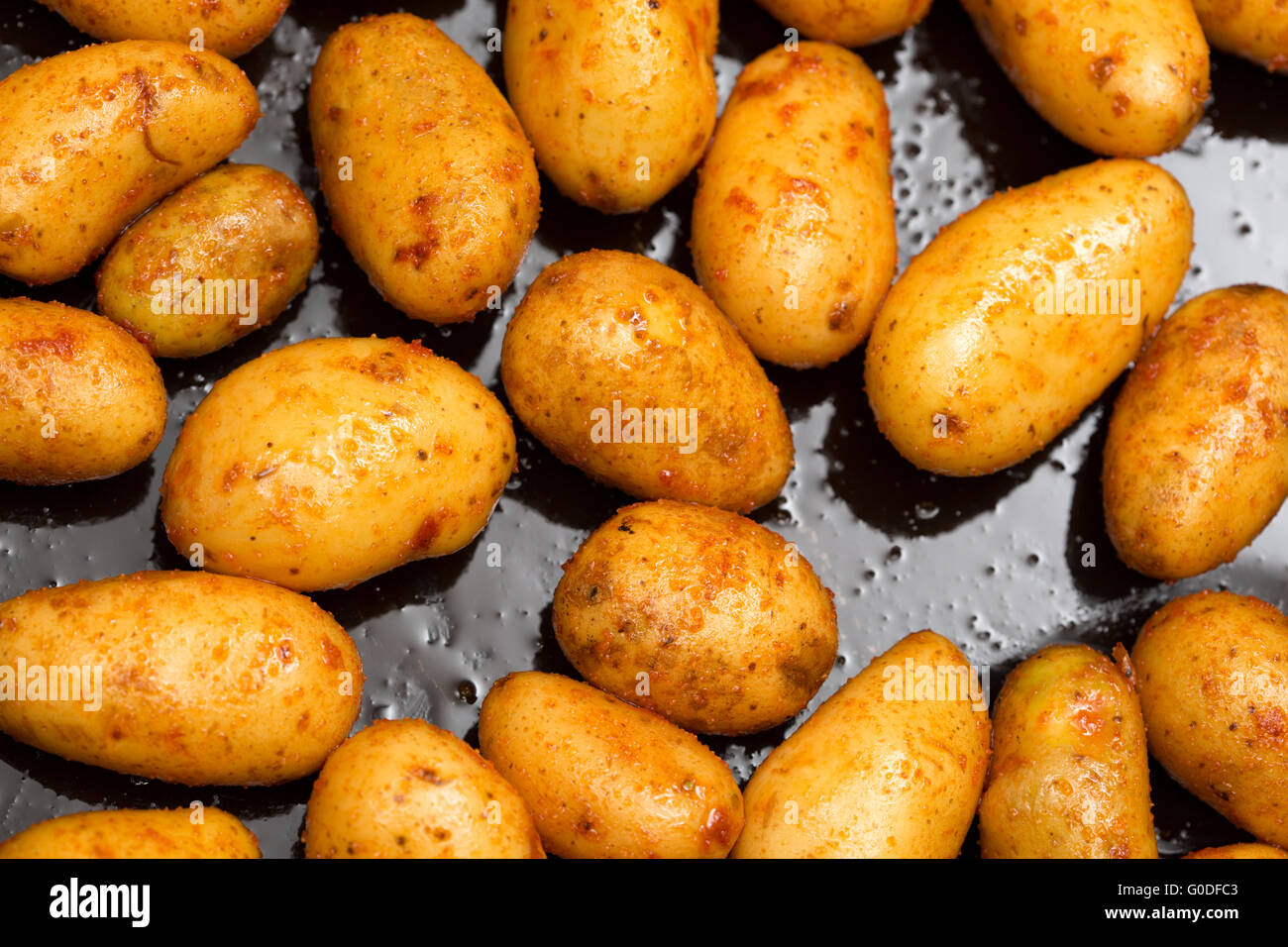 Shiny fresh, oiled potatoes on an oven plate Stock Photo - Alamy