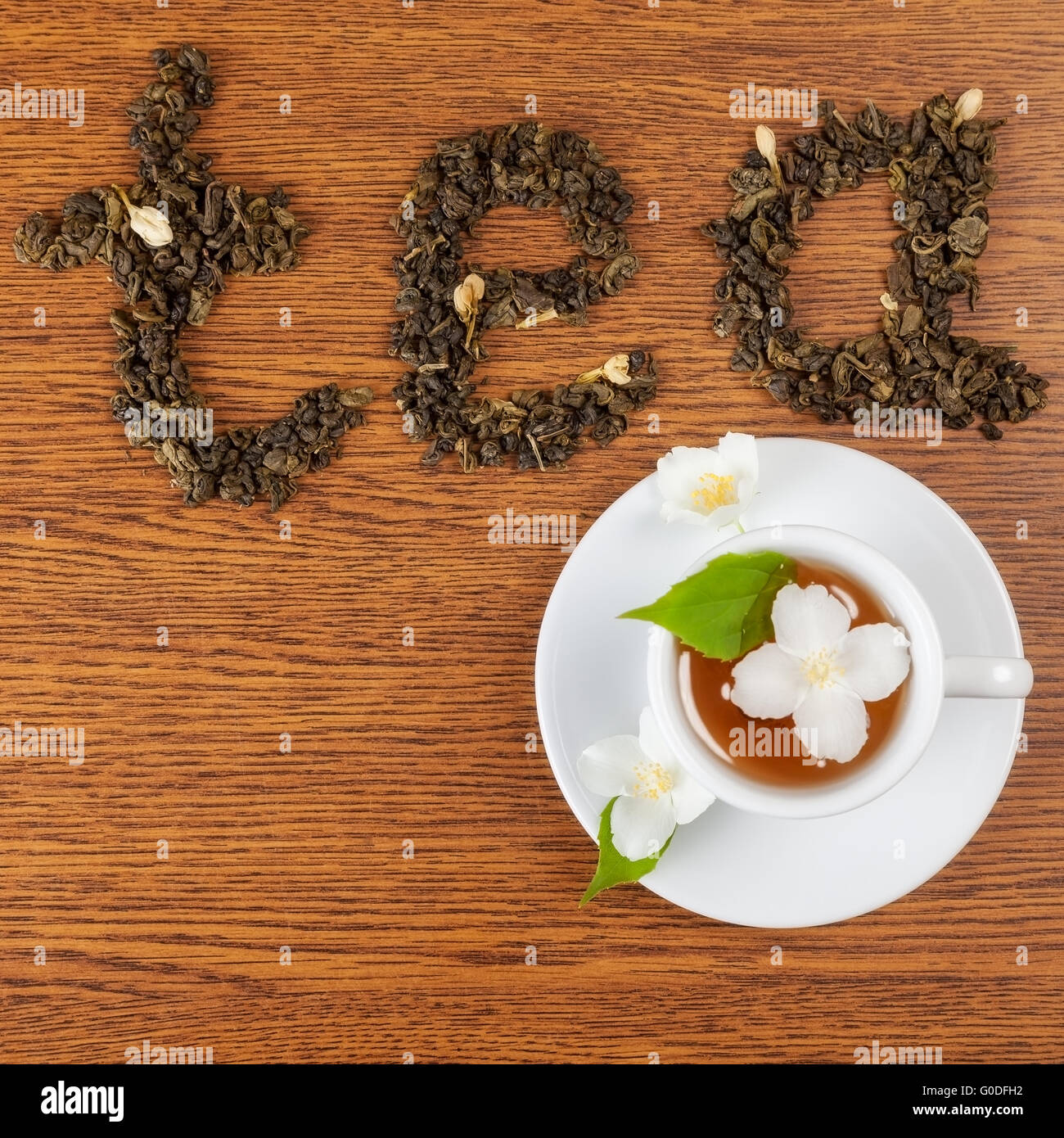 the word tea from leaves of green tea on a wooden surface next to a ...