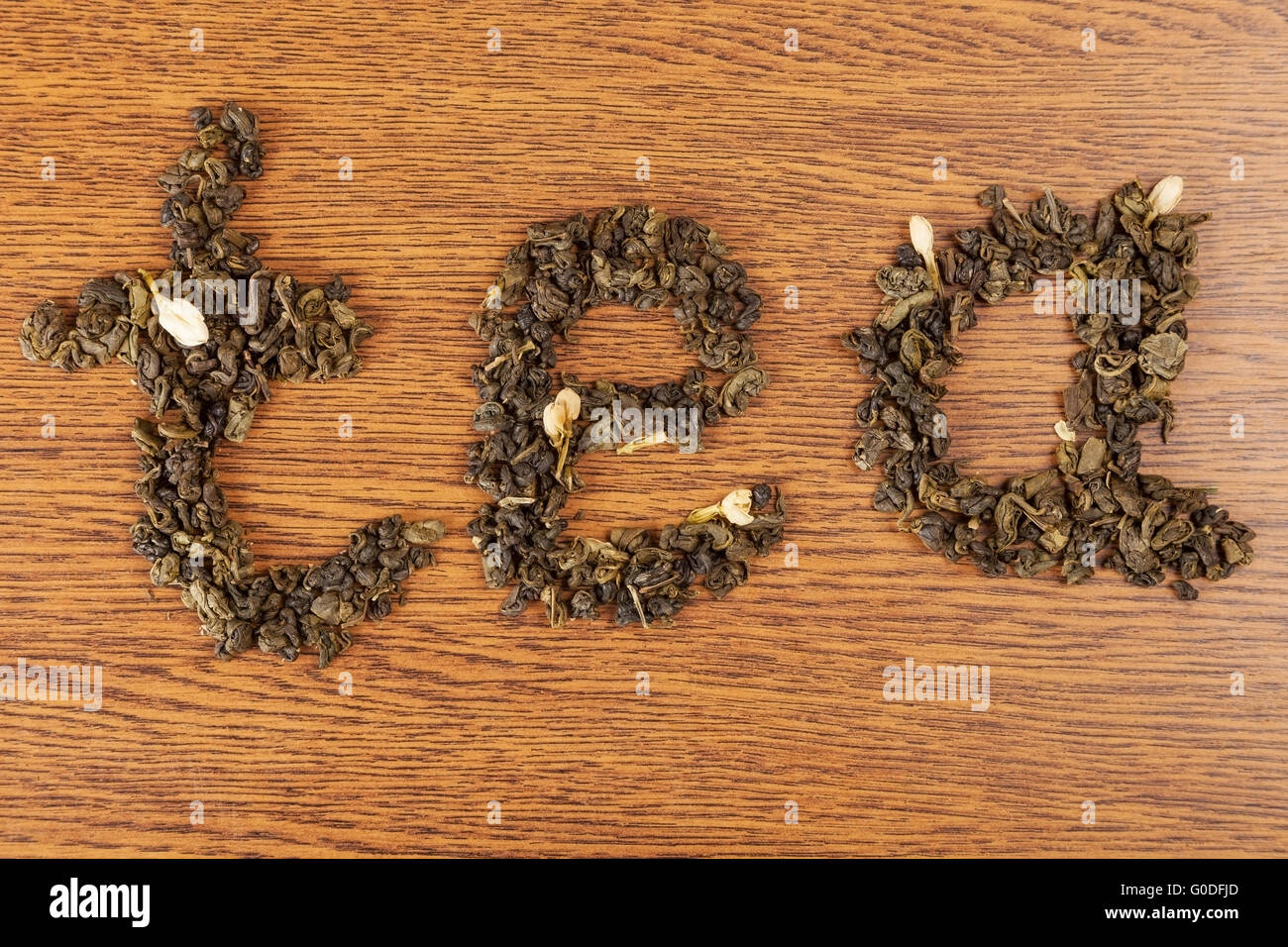 the word tea from leaves of green tea with jasmine on a wooden surface ...