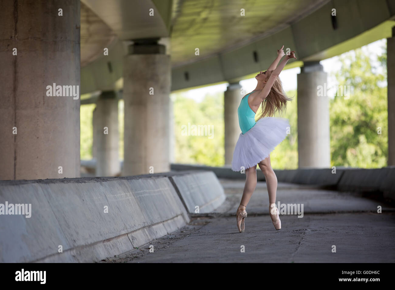 Graceful ballerina doing dance exercises on a concrete bridge Stock ...