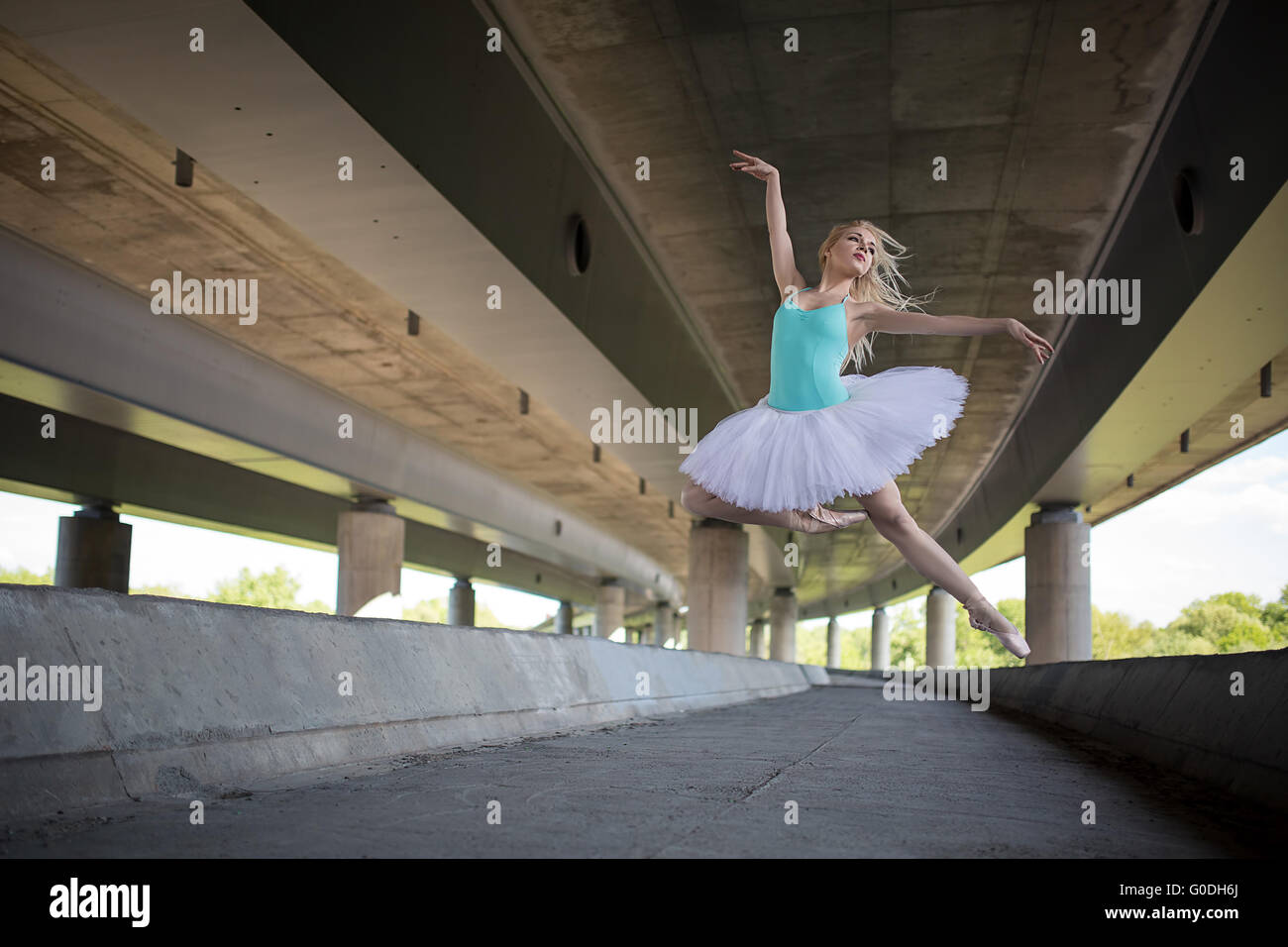 Graceful ballerina doing dance exercises on a concrete bridge Stock ...
