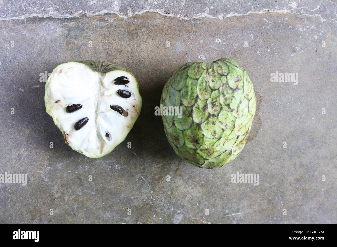 Whole cherimoya fruit and half cherimoya on a cement slab Stock Photo ...