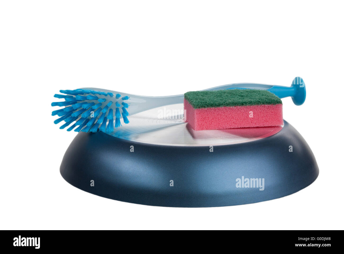 Sponge and brush for ware lie the turned frying pan Stock Photo - Alamy