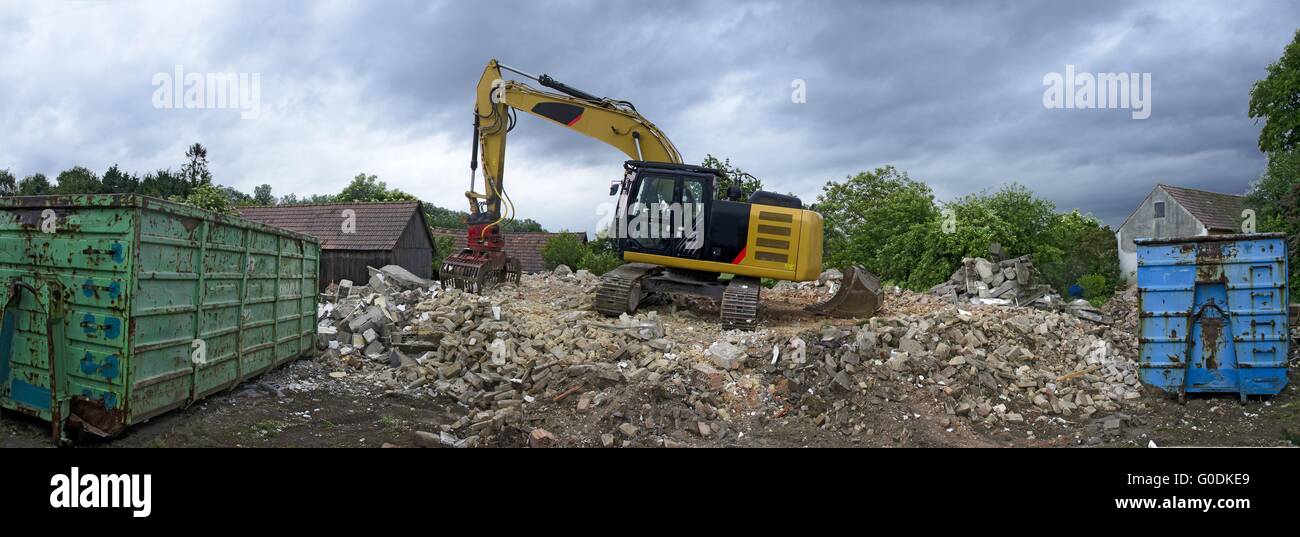 digger with a picker arm on a mountain of rubble Stock Photo - Alamy