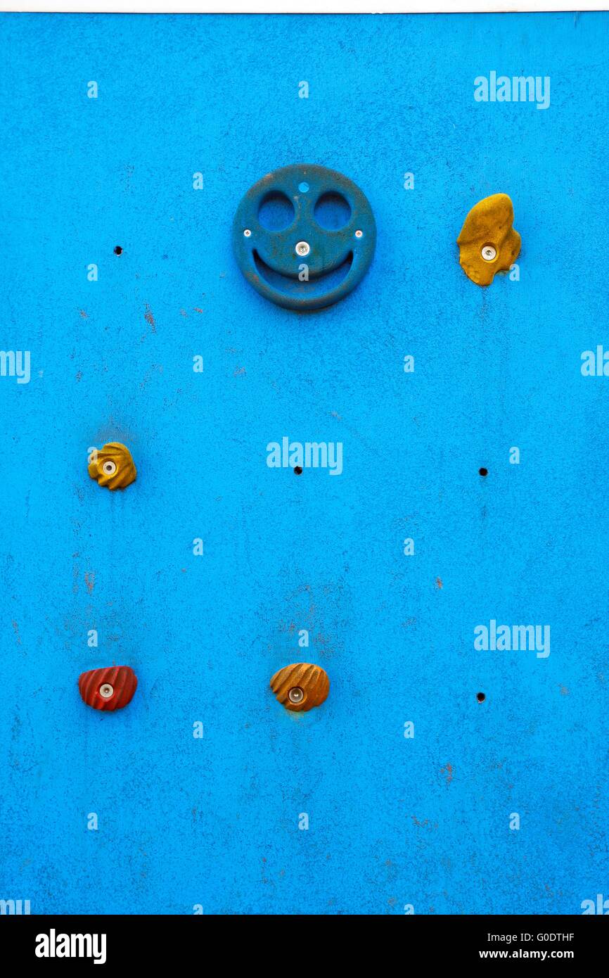 Blue climbing wall background with smiley grip Stock Photo - Alamy