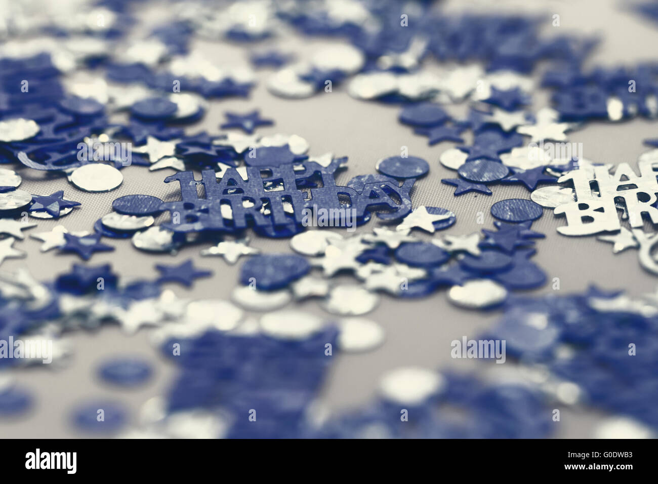 Blue happy birthday confetti pieces - macro photo Stock Photo - Alamy