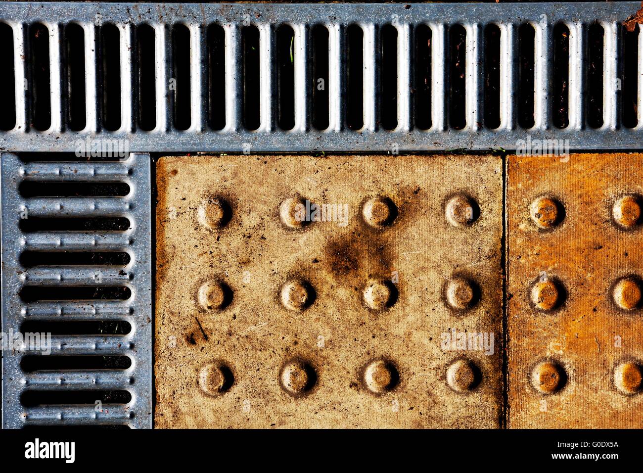 Urban textured paving and drain cover background Stock Photo - Alamy