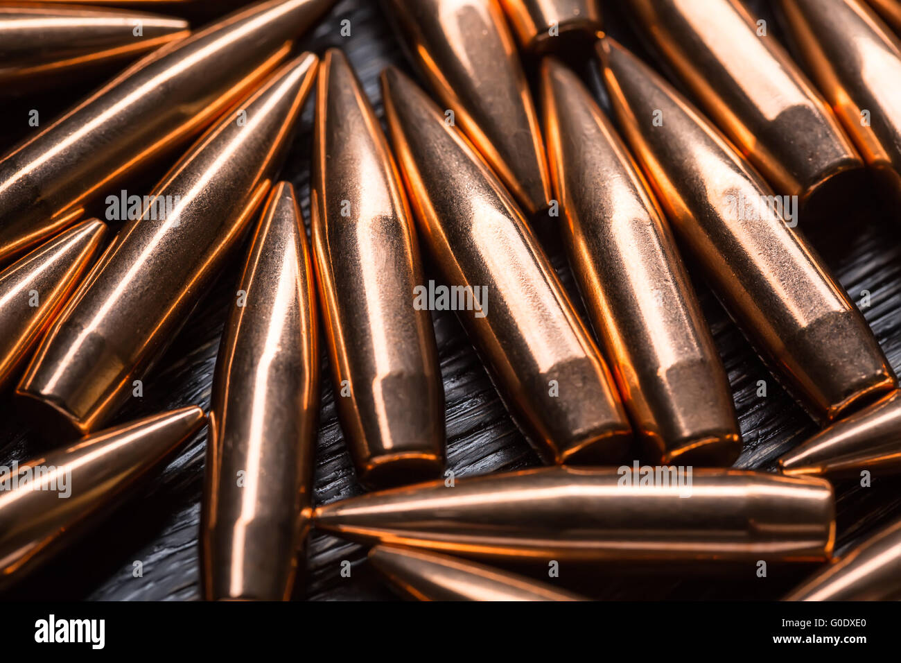Placer copper bullets on a dark wooden background Stock Photo - Alamy
