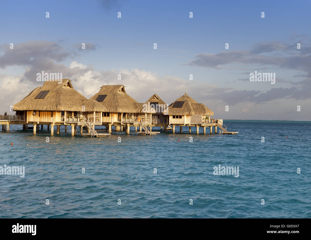 Polynesian landscape -small houses on water Stock Photo - Alamy
