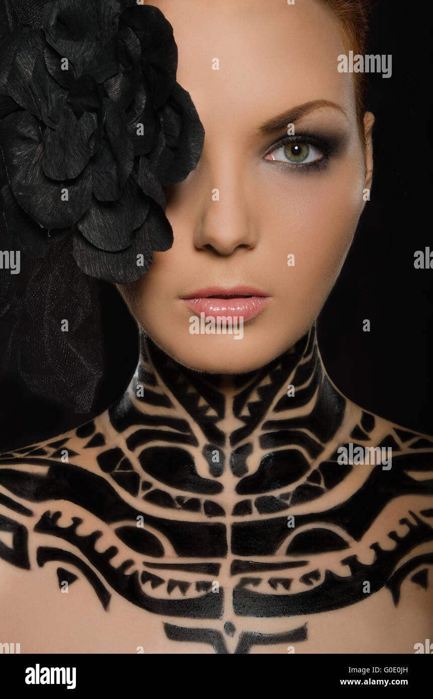Portrait of woman with flower and black body art Stock Photo - Alamy