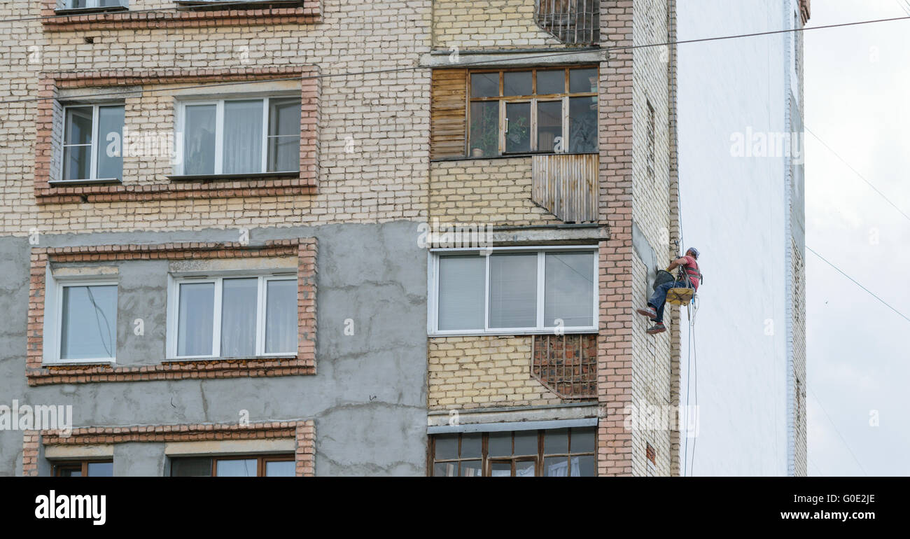 Builder-climber hanging on a rope from the roof Stock Photo - Alamy