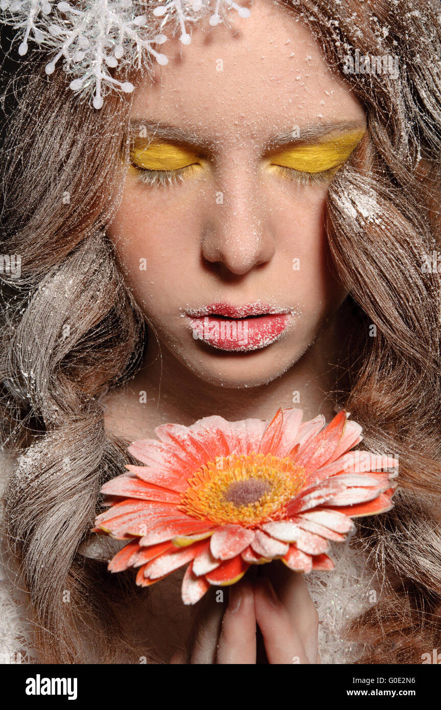 girl with flower in his hand under falling snow Stock Photo - Alamy