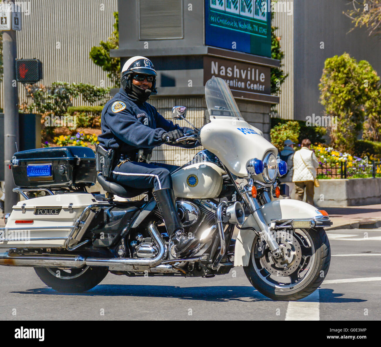 A smiling African American motorcycle policeman traveling by the ...