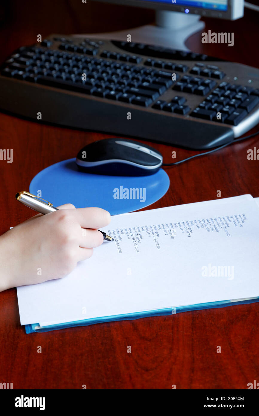 hand with a pen and computer in the background Stock Photo - Alamy