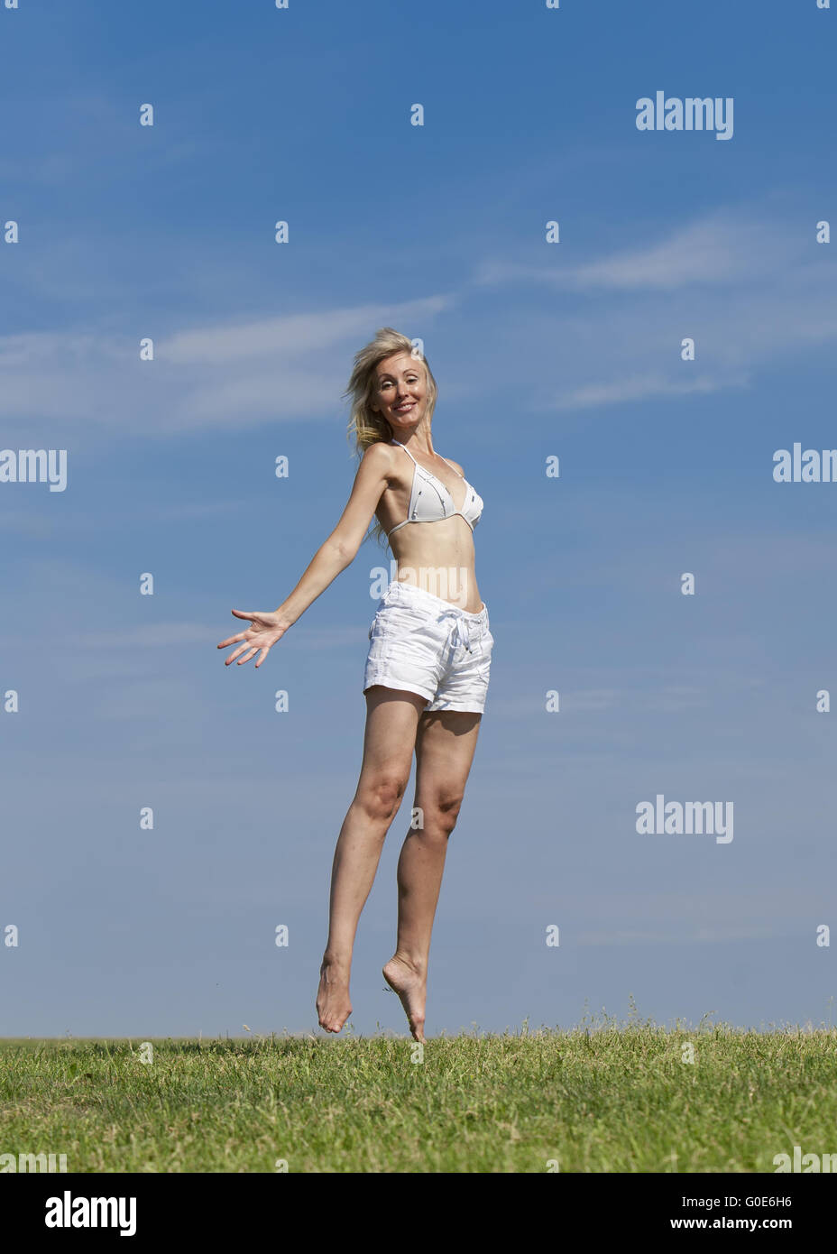 woman in white bikini and shorts jumps in a summer Stock Photo - Alamy