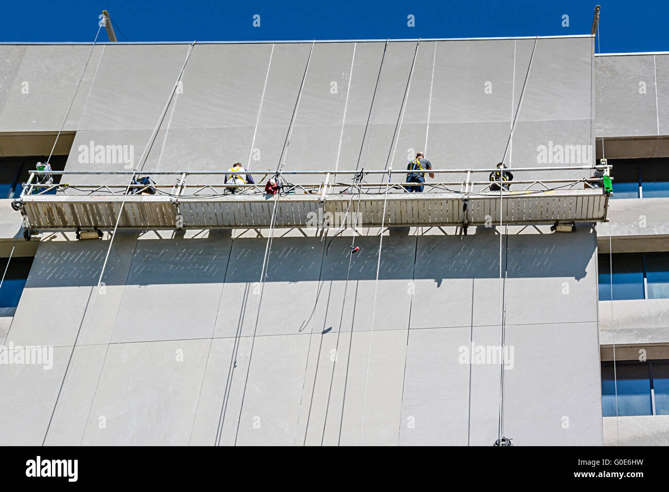 A suspended Scaffolding platform high above the street on a high rise ...
