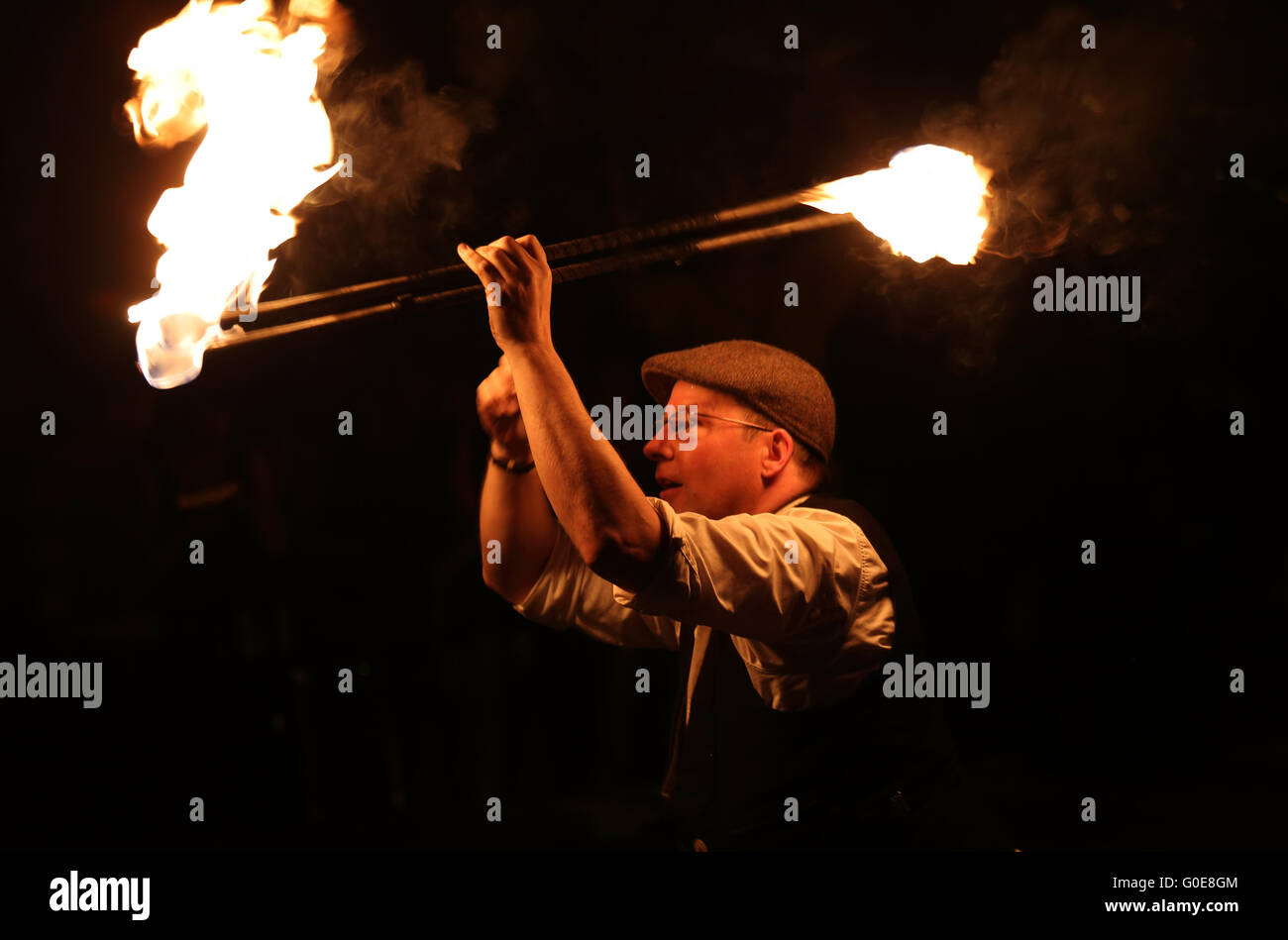 Male fire dancer twirling two large fiery batons overhead Stock Photo ...
