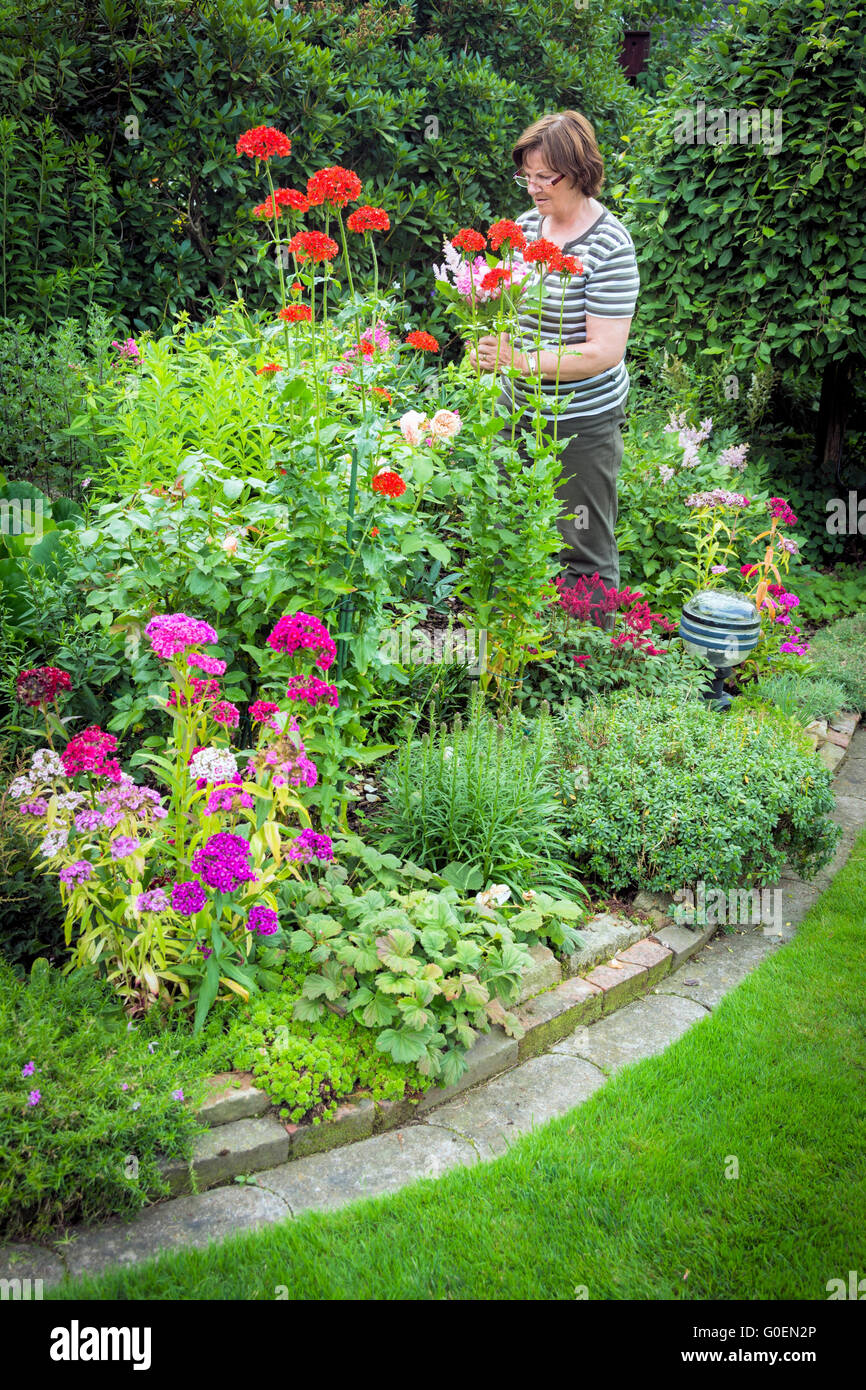 Woman picking flowers in the garden Stock Photo - Alamy