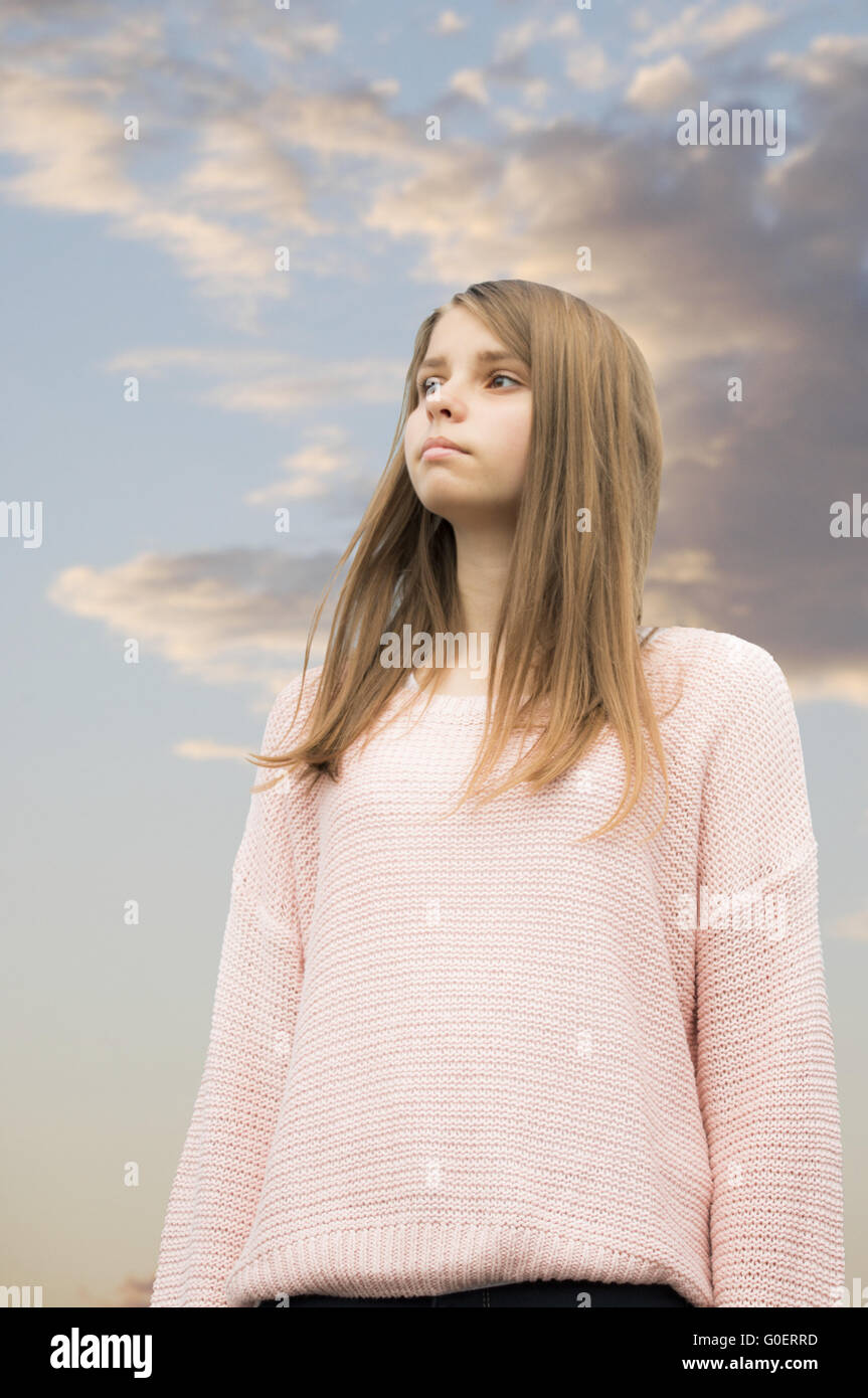 Teenage girl on cloudy sky background Stock Photo - Alamy