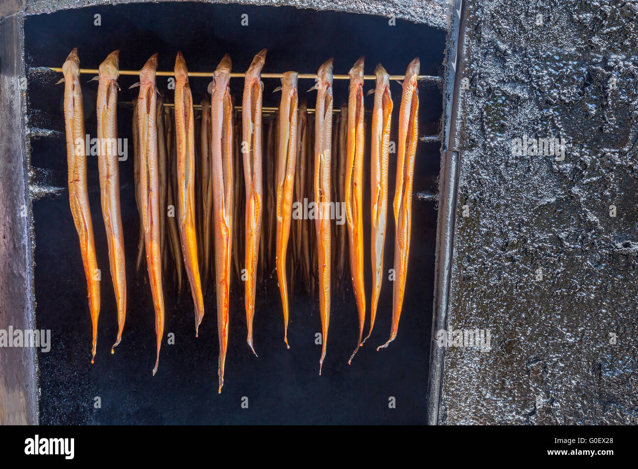 Many hanging eels are being smoked Stock Photo - Alamy