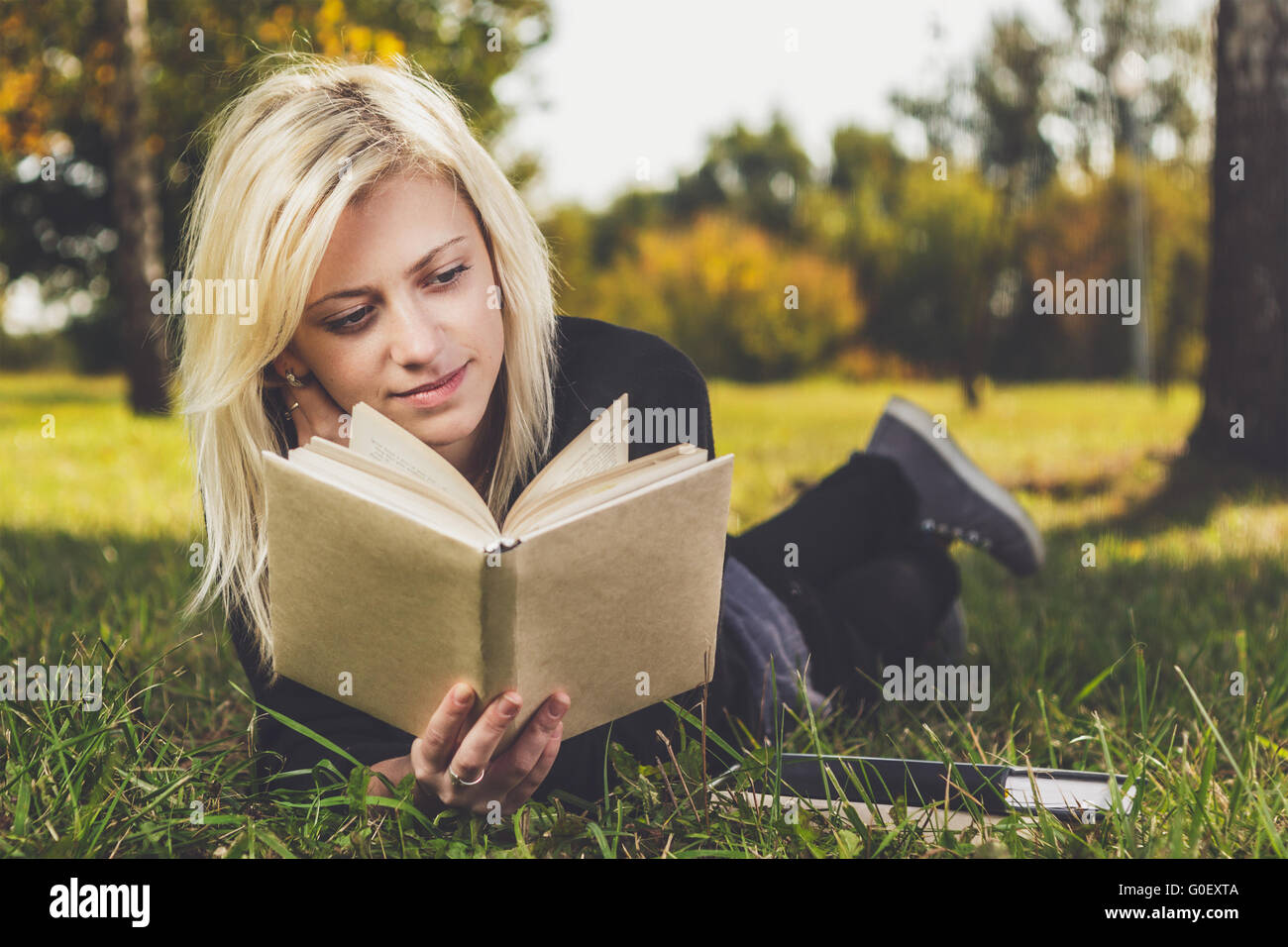 girl reading in park on grass Stock Photo - Alamy