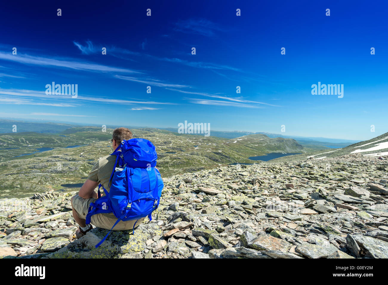 Hiker with big traveling rucksack looking forward on the mountain trail ...