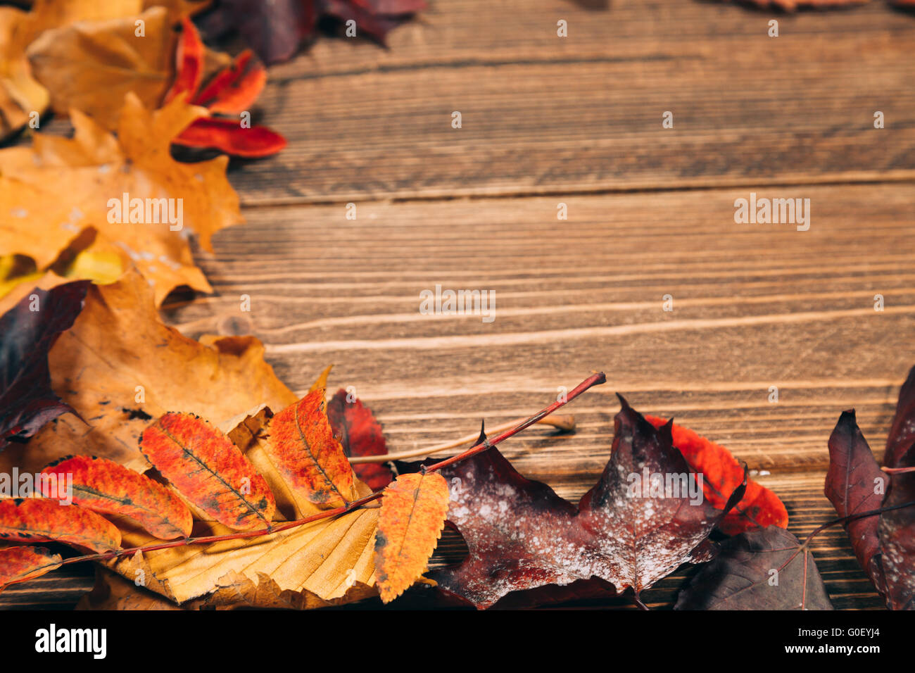 Background with wooden table and autumnal leaves Stock Photo - Alamy