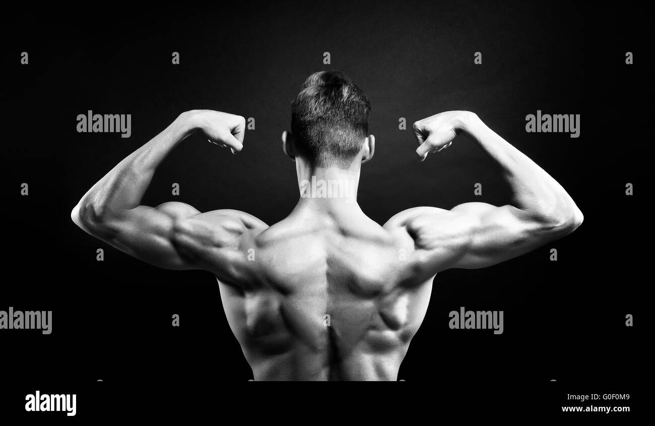 Muscular male back on black background Stock Photo - Alamy