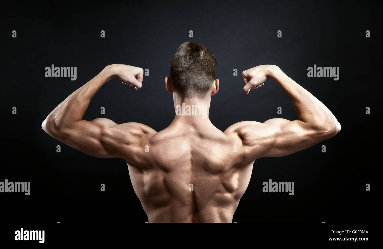 Muscular male back on black background Stock Photo - Alamy