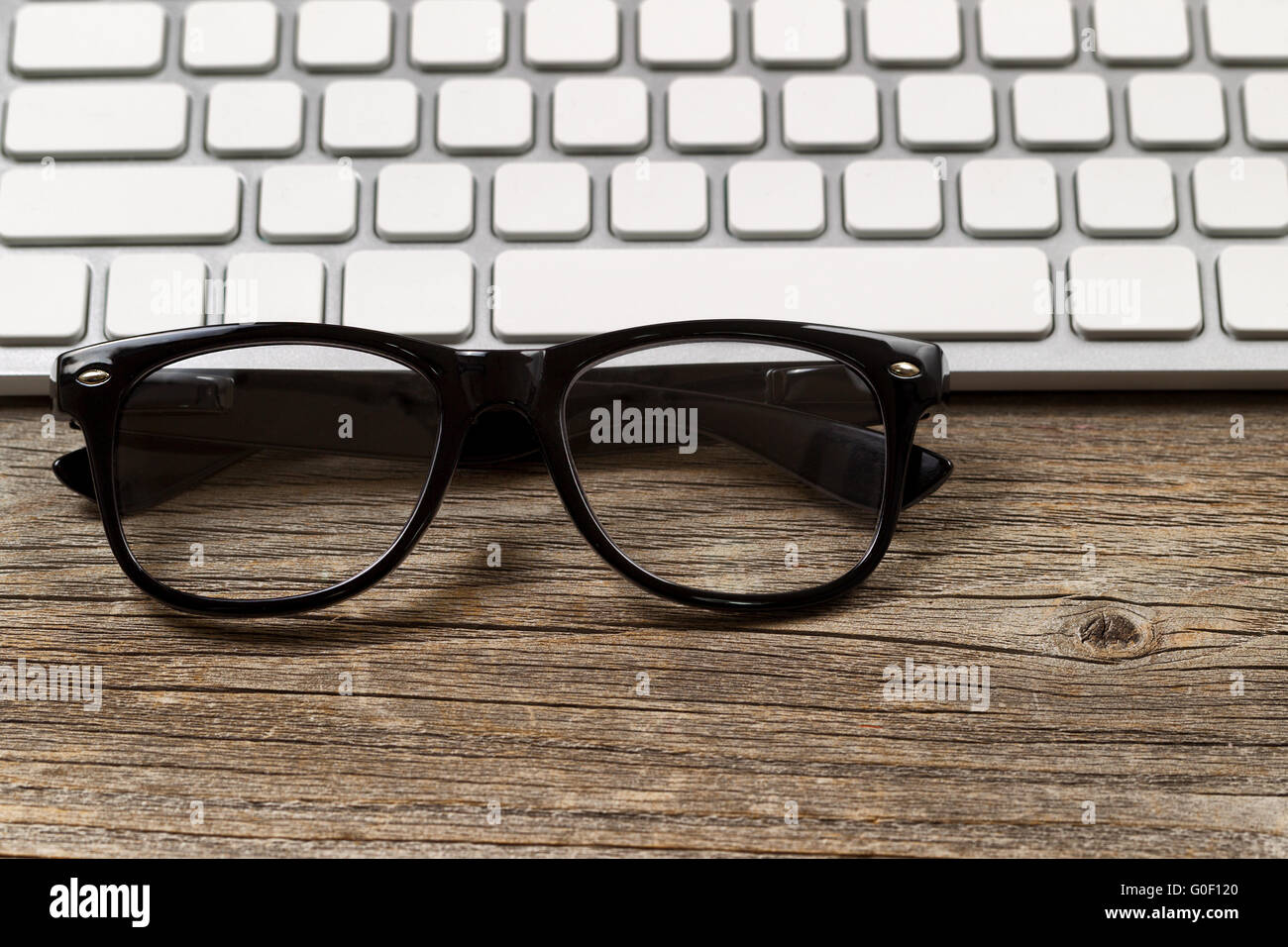 Hipster reading glasses with keyboard on rustic wooden desktop Stock ...